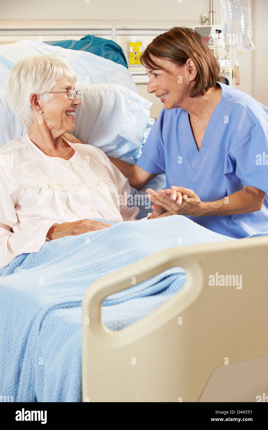 Nurse Talking To Senior Female Patient In Hospital Bed Stock Photo - Alamy
