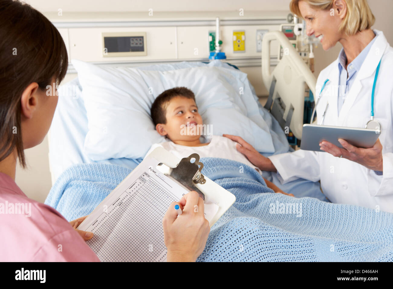 Doctor Using Digital Notepad Whilst Visiting Child Patient Stock Photo ...