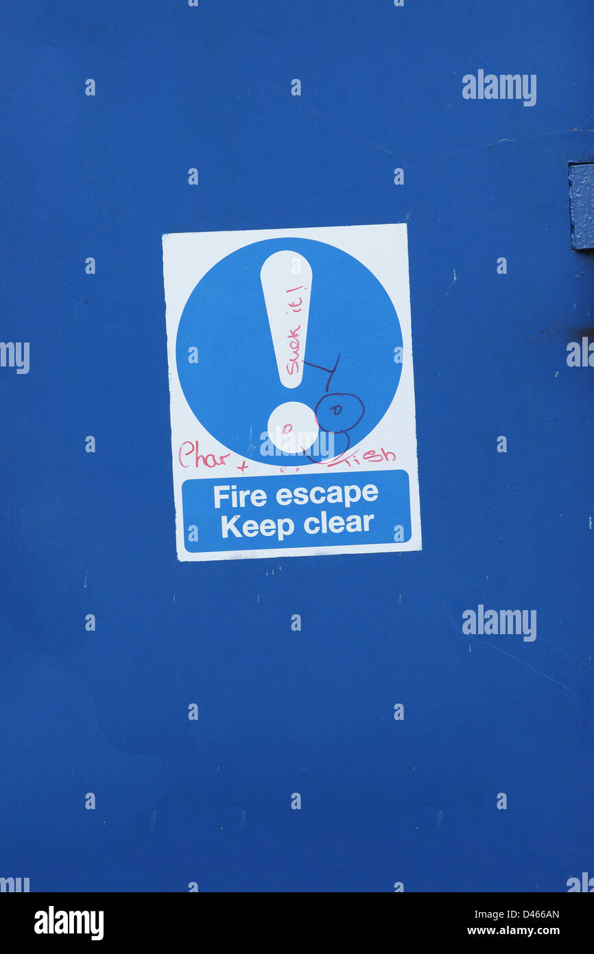 A blue Fire Escape keep clear sign coved in a blue background with ...