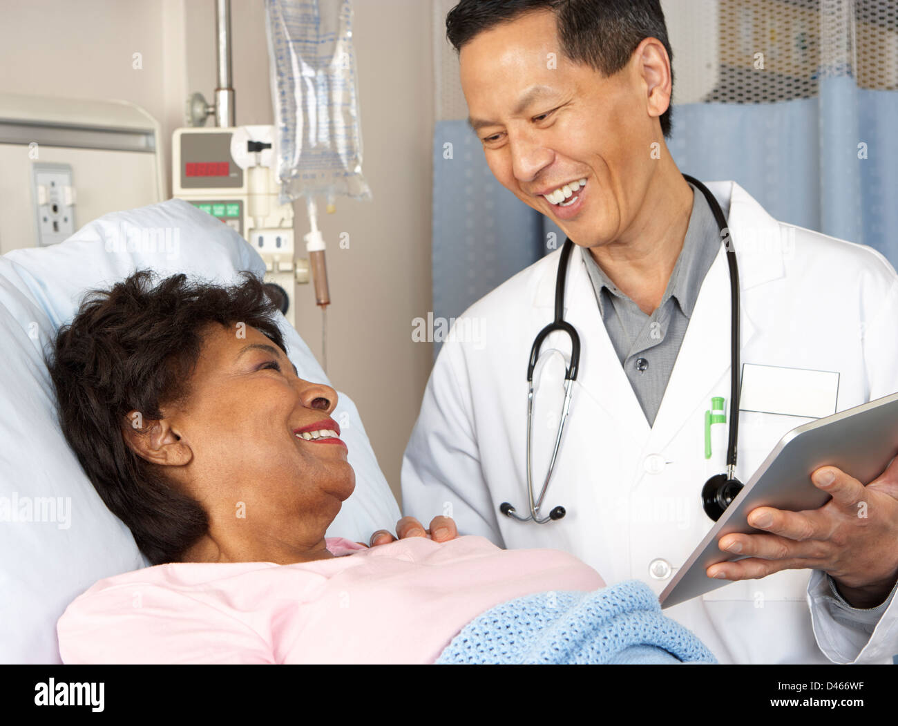 Doctor Using Digital Tablet Talking With Senior Patient Stock Photo - Alamy