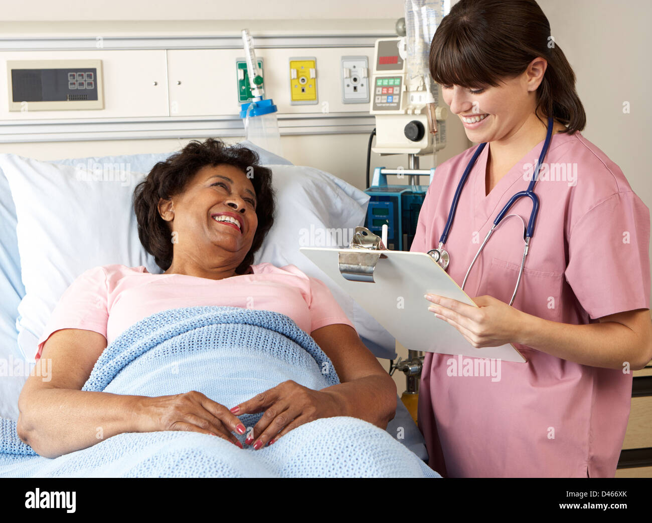 Nurse Visiting Senior Female Patient On Ward Stock Photo - Alamy