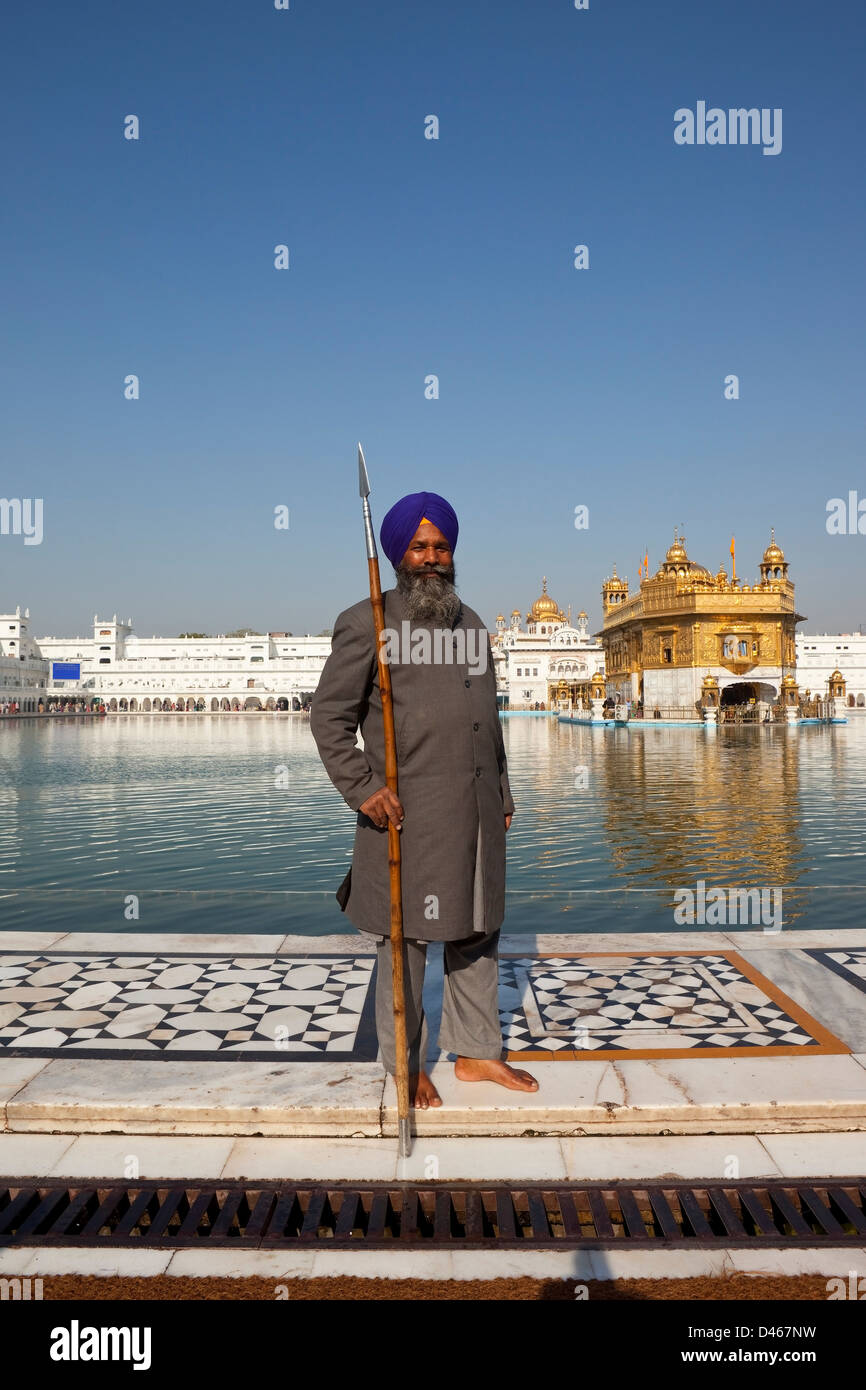 A Sikh temple guard in front of the beautiful Golden Temple at Amritsar ...