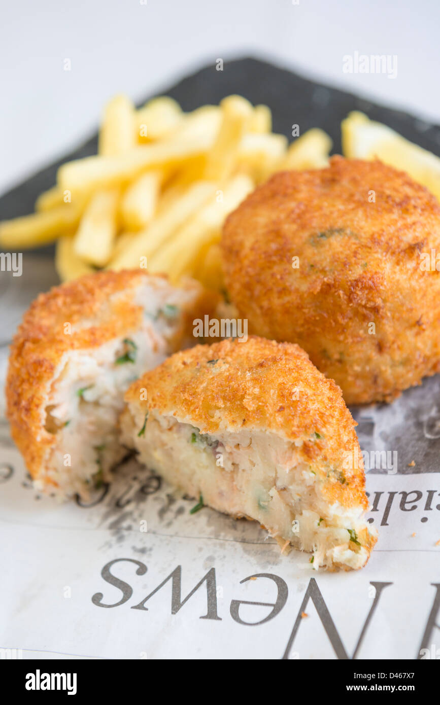 Salmon fish cakes and chips served on newspaper Stock Photo - Alamy