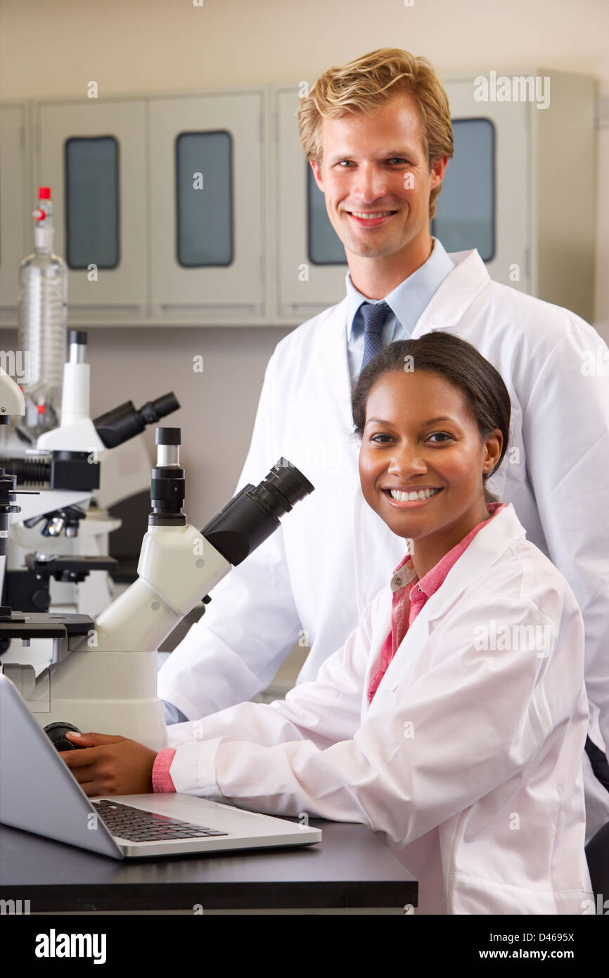 Male And Female Scientists Using Microscopes In Laboratory Stock Photo ...