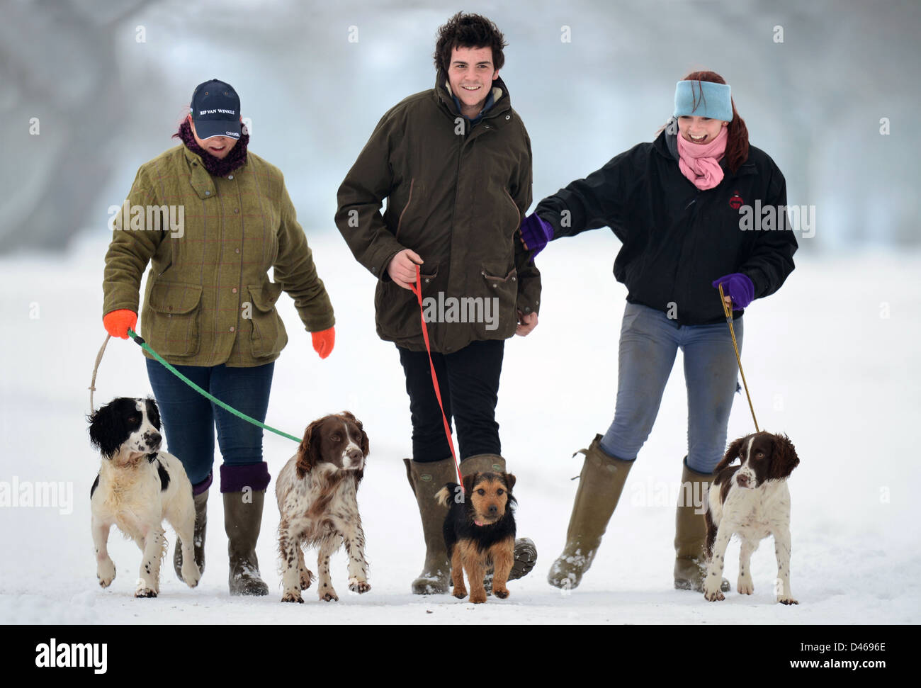 Three young people exercising their dogs in Badminton Park ...