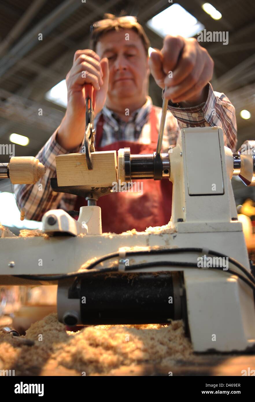 A master wood turner puts a piece of wood in his machine at the ...