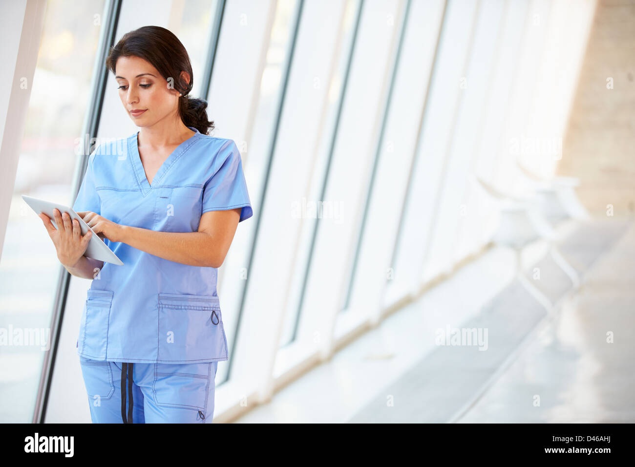 Nurse Using Digital Tablet In Corridor Of Modern Hospital Stock Photo ...
