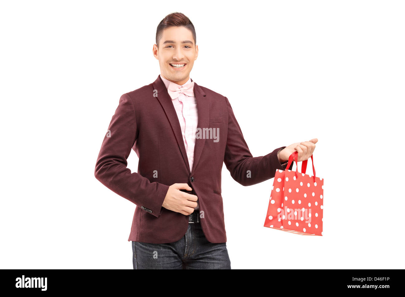 Handsome young man holding a shopping bag isolated on white background ...