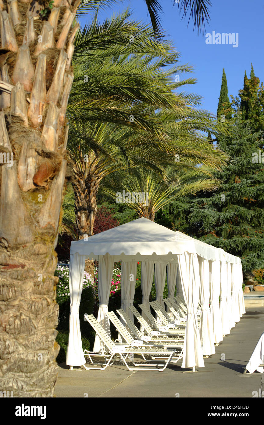 White tents at a tropical resort pool side Stock Photo - Alamy
