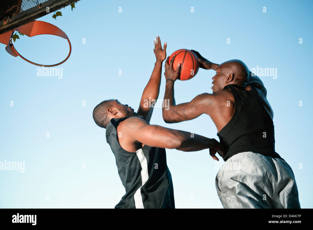 Two young black men playing basketball after work Stock Photo - Alamy