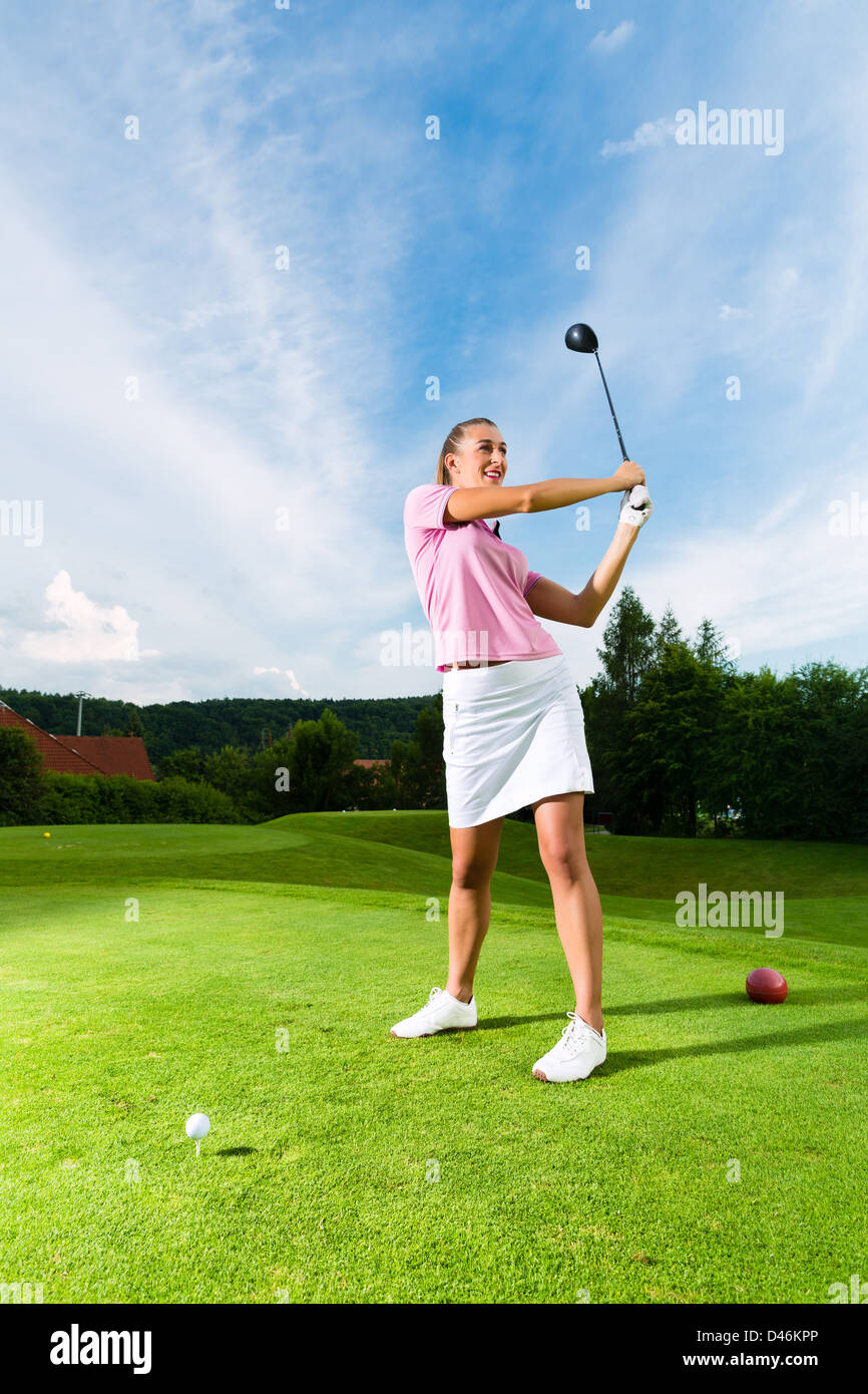 Young female golf player on course doing golf swing, she presumably ...