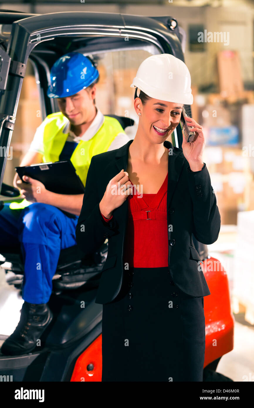 Forklift driver with clipboard at warehouse of freight forwarding ...