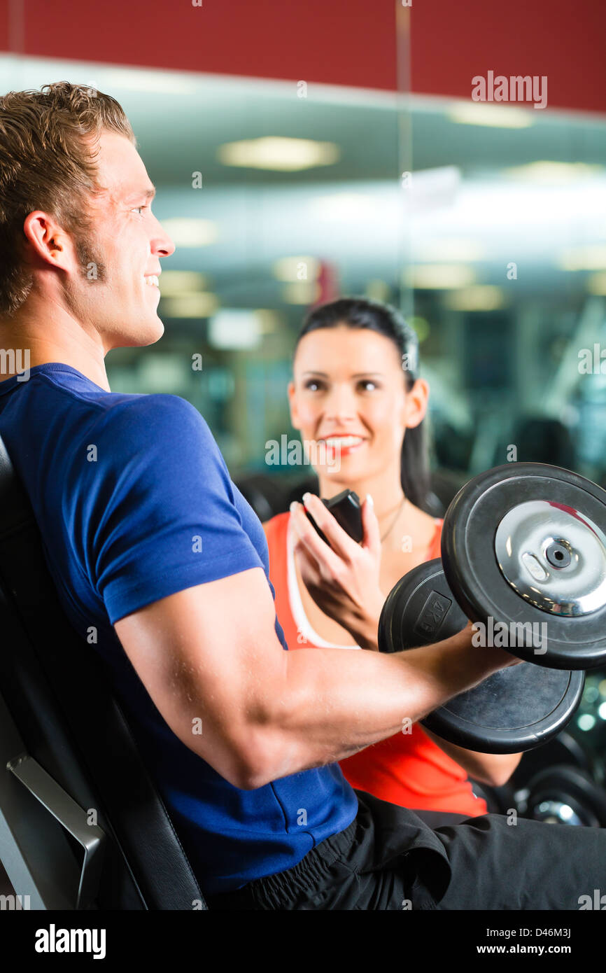 Man or Bodybuilder with his personal fitness trainer in the gym ...