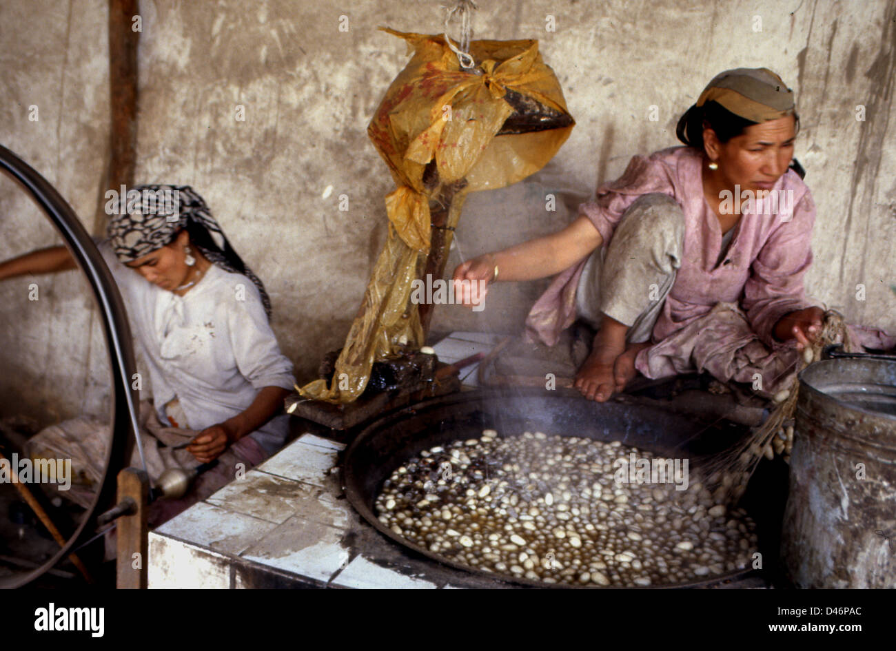 Uighur women boiling silk cocoons in Xinjiang region China Stock Photo ...