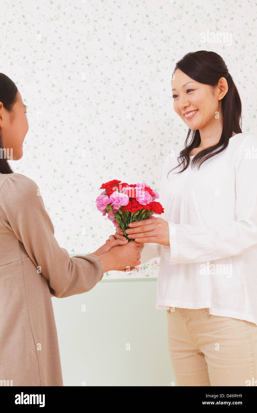Girl Giving Flower Present To Her Mother Stock Photo - Alamy