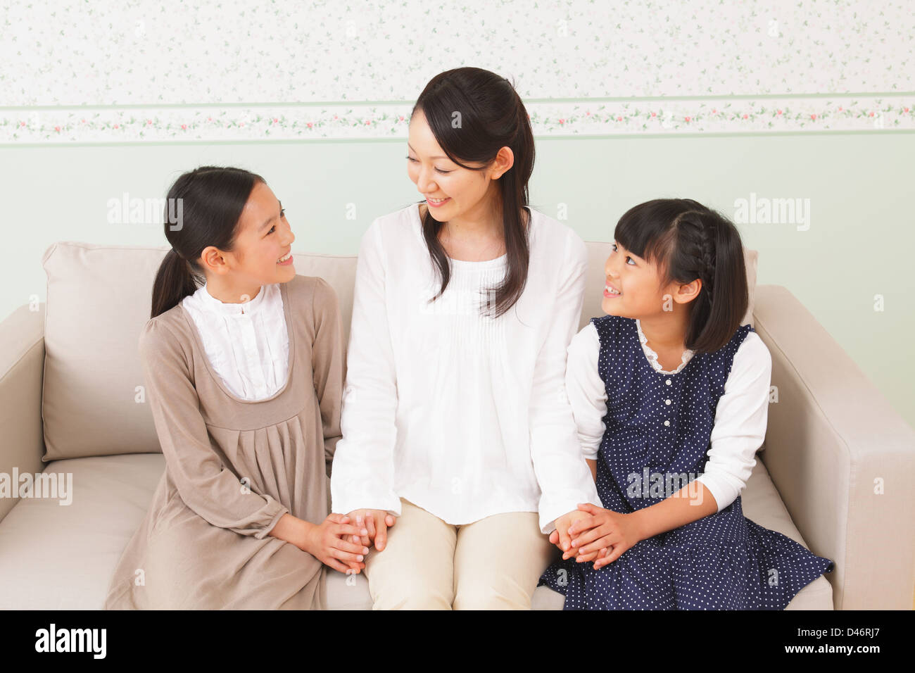 Mother And Daughters Sitting On the Sofa Stock Photo - Alamy