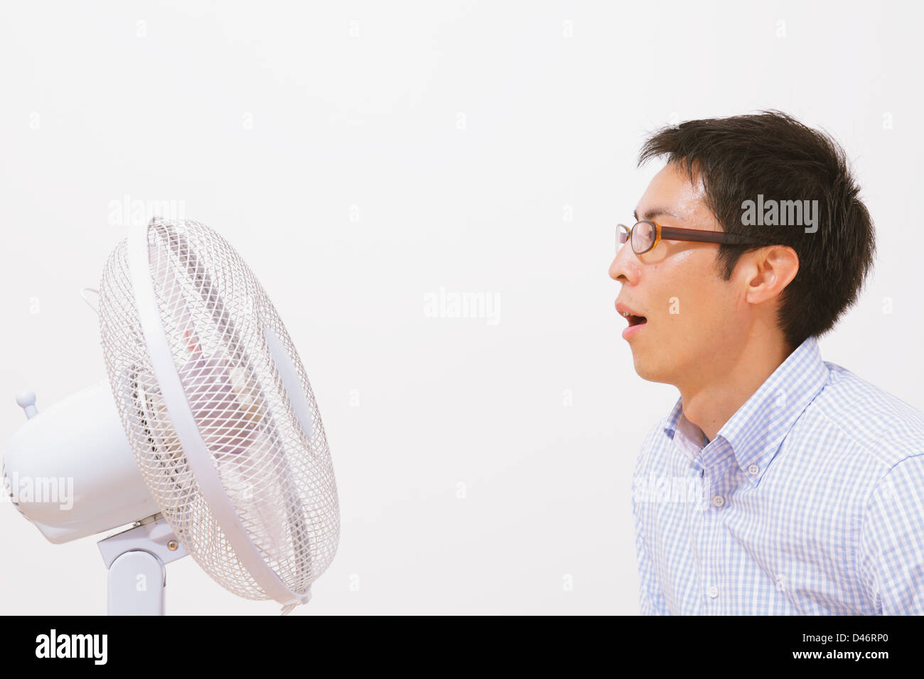 Man Cooling Down With a Fan Stock Photo - Alamy