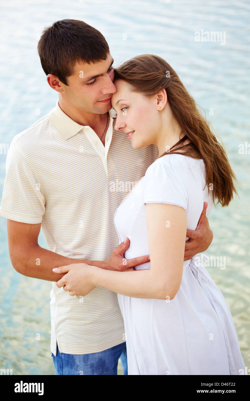 Photo of peaceful couple enjoying being together with blue water on ...