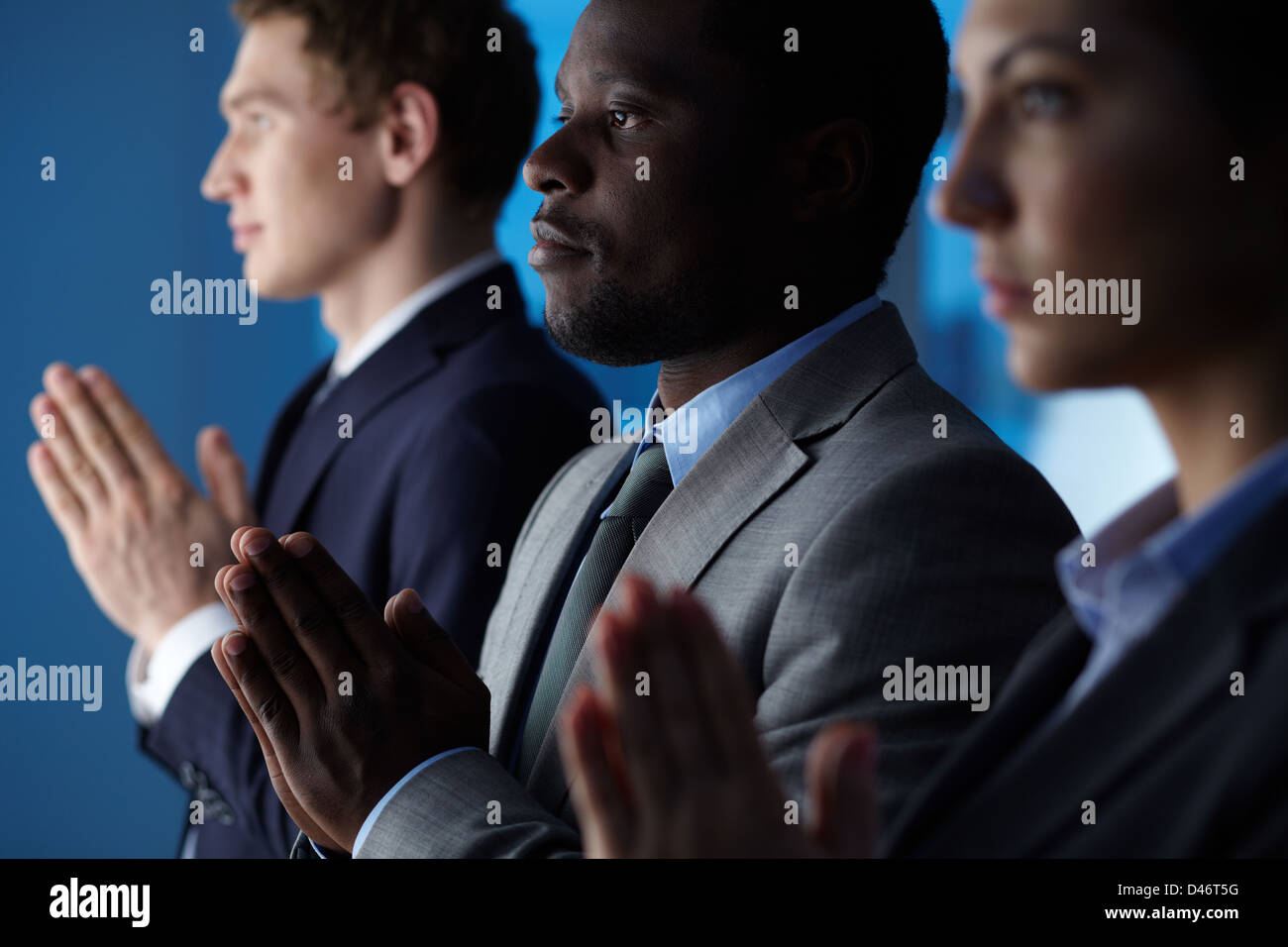 Group of business partners praying for their new project Stock Photo ...