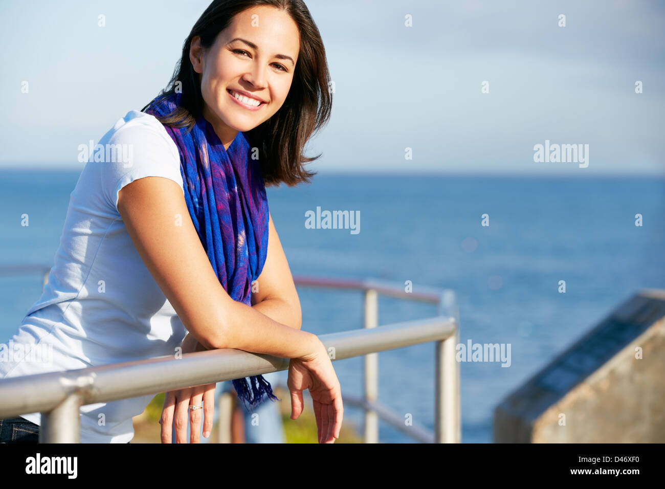 Hispanic Woman Looking Over Railing At Sea Stock Photo - Alamy