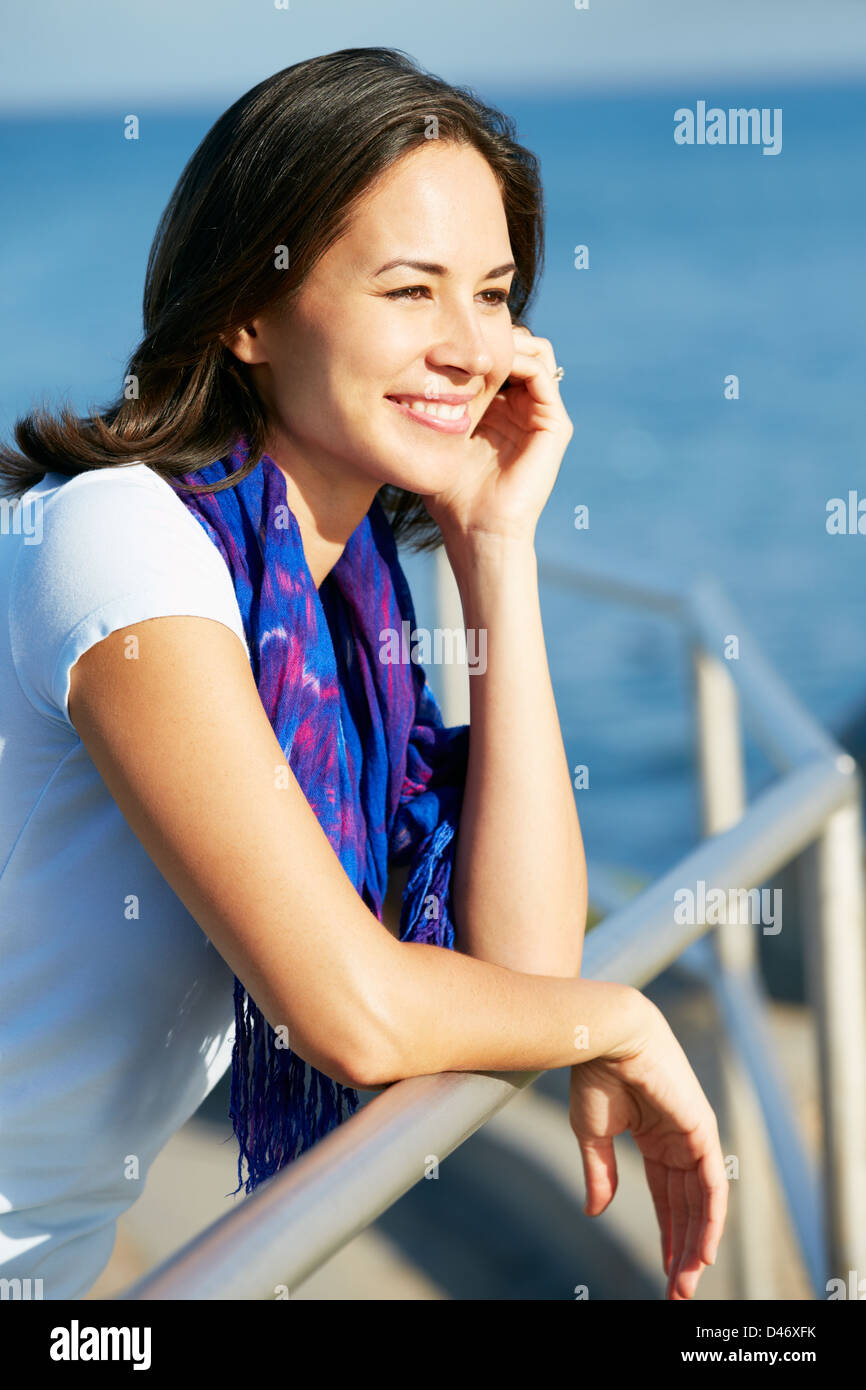 Hispanic Woman Looking Over Railing At Sea Stock Photo - Alamy