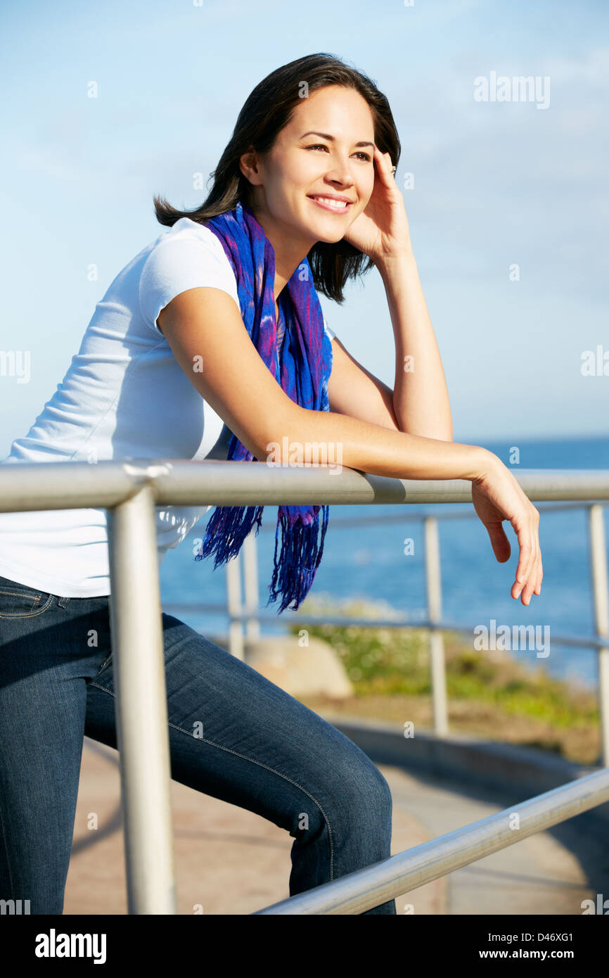 Hispanic Woman Looking Over Railing At Sea Stock Photo - Alamy