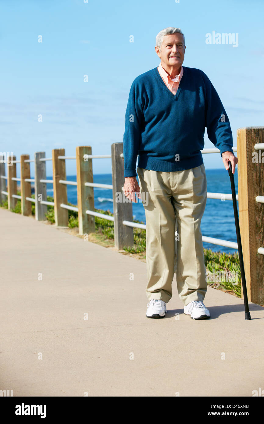 Senior Man Walking Along Path By The Sea Stock Photo - Alamy