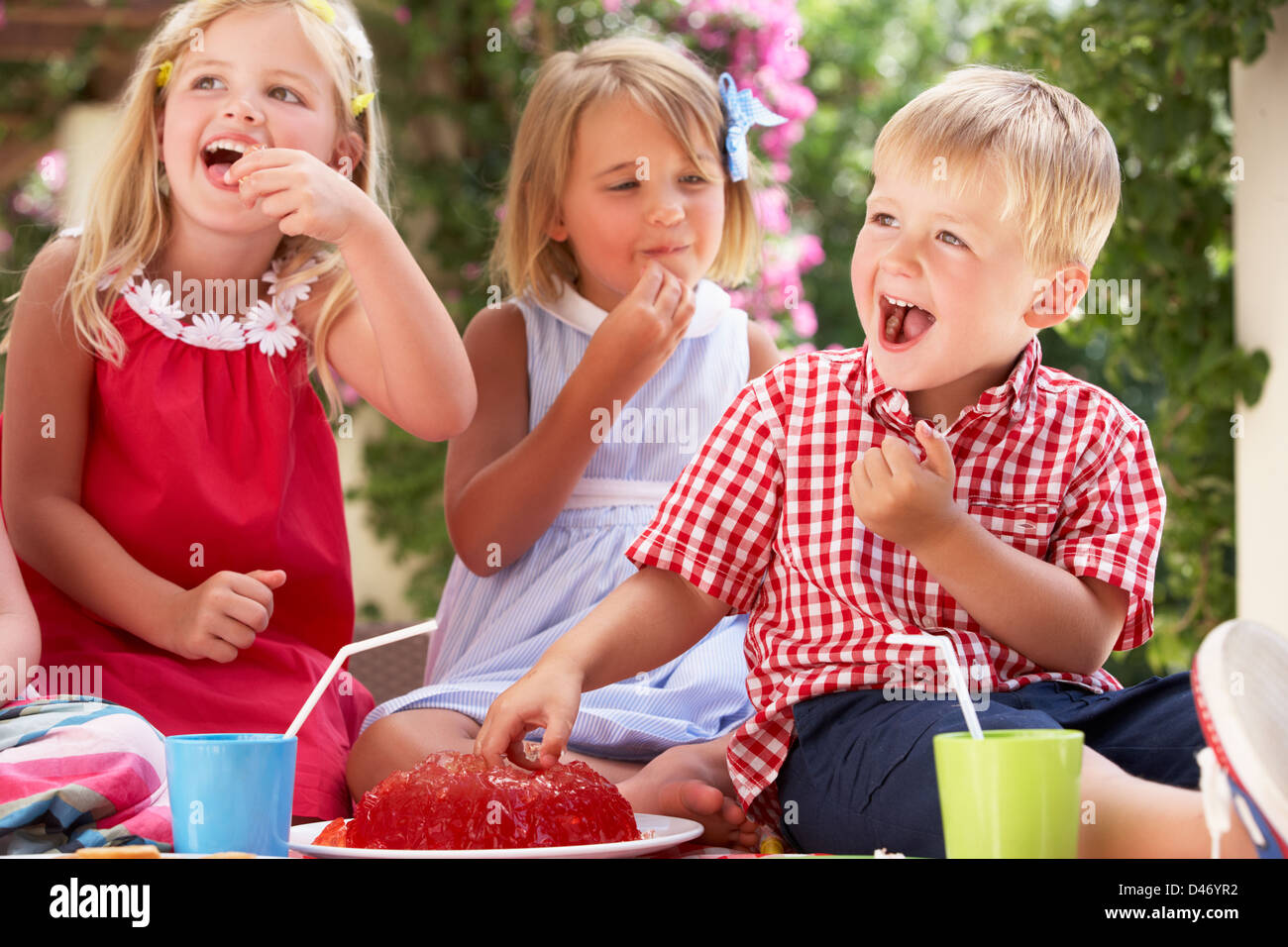 Group Of Children Eating Jelly At Outdoor Tea Party Stock Photo - Alamy