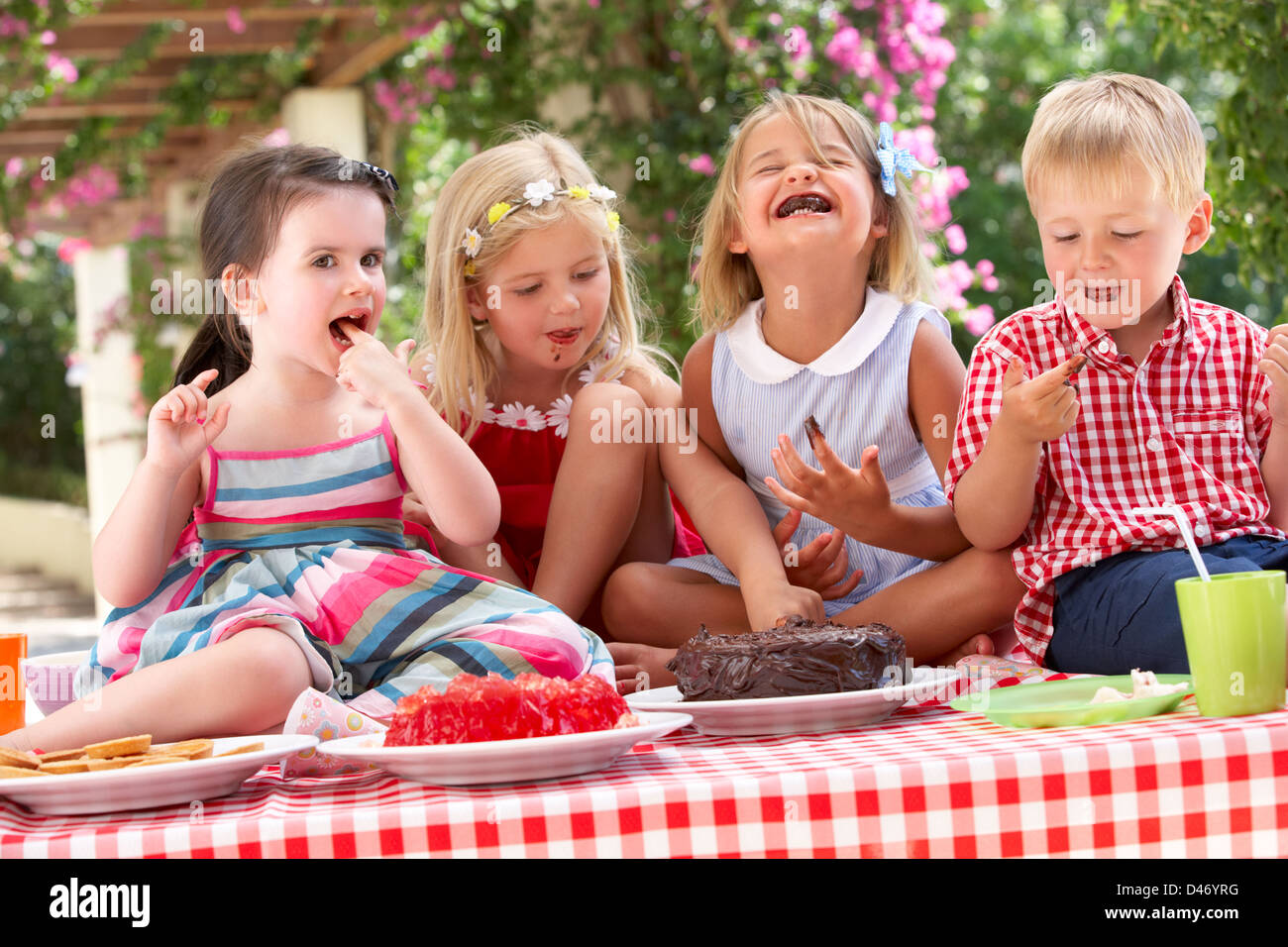 Group Of Children Eating Jelly And Cake At Outdoor Tea Party Stock ...