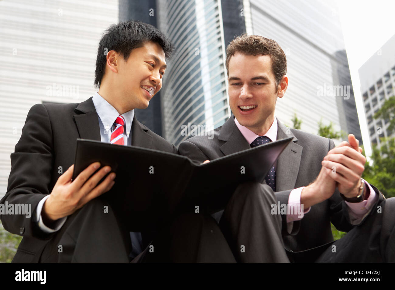 Two Businessmen Discussing Document Outside Office Stock Photo - Alamy