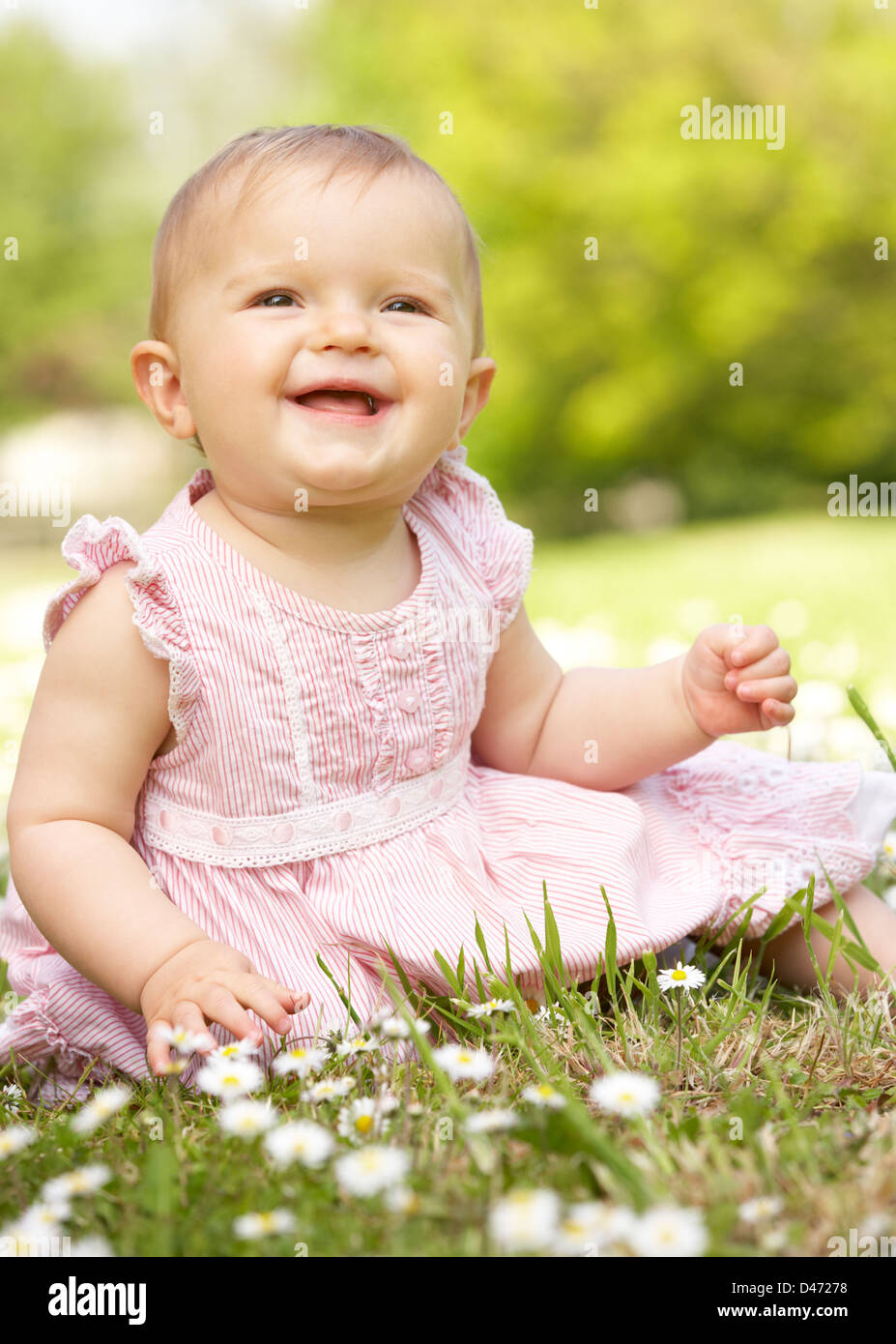 Baby Girl In Summer Dress Sitting In Field Stock Photo - Alamy