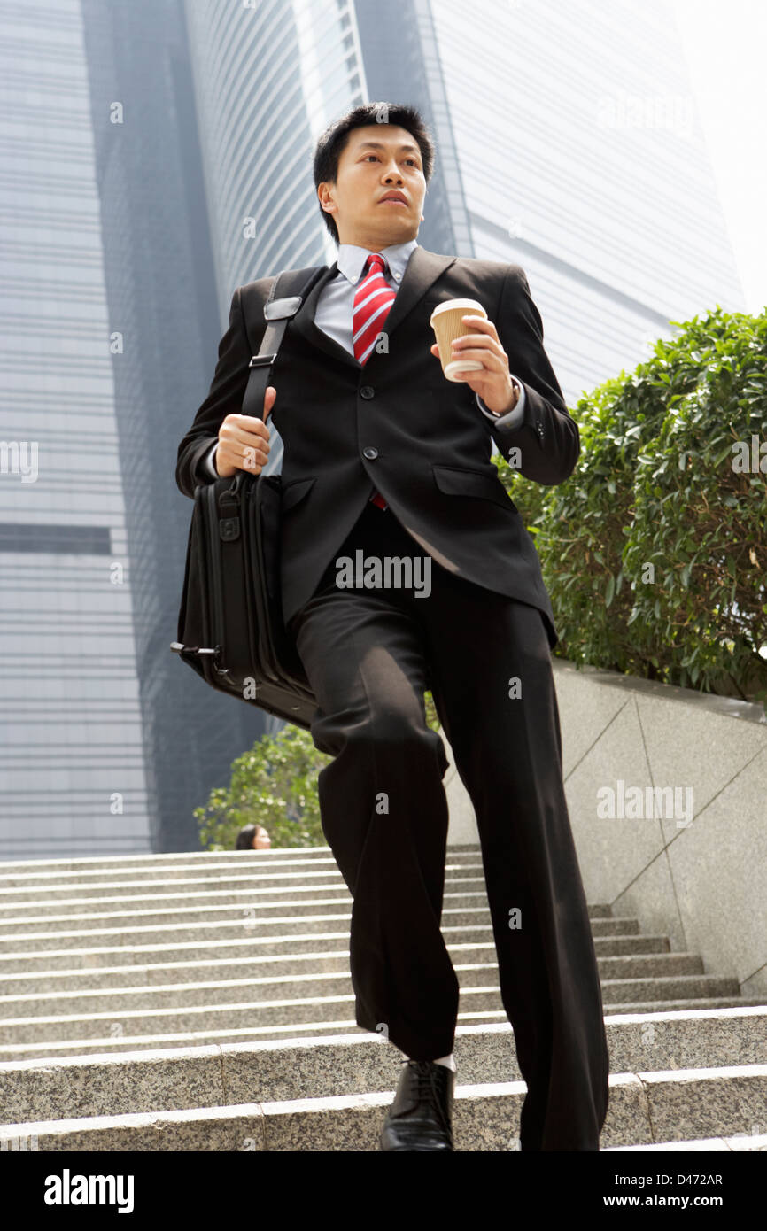 Chinese Businessman Rushing Down Steps Carrying Bag And Takeaway Coffee ...