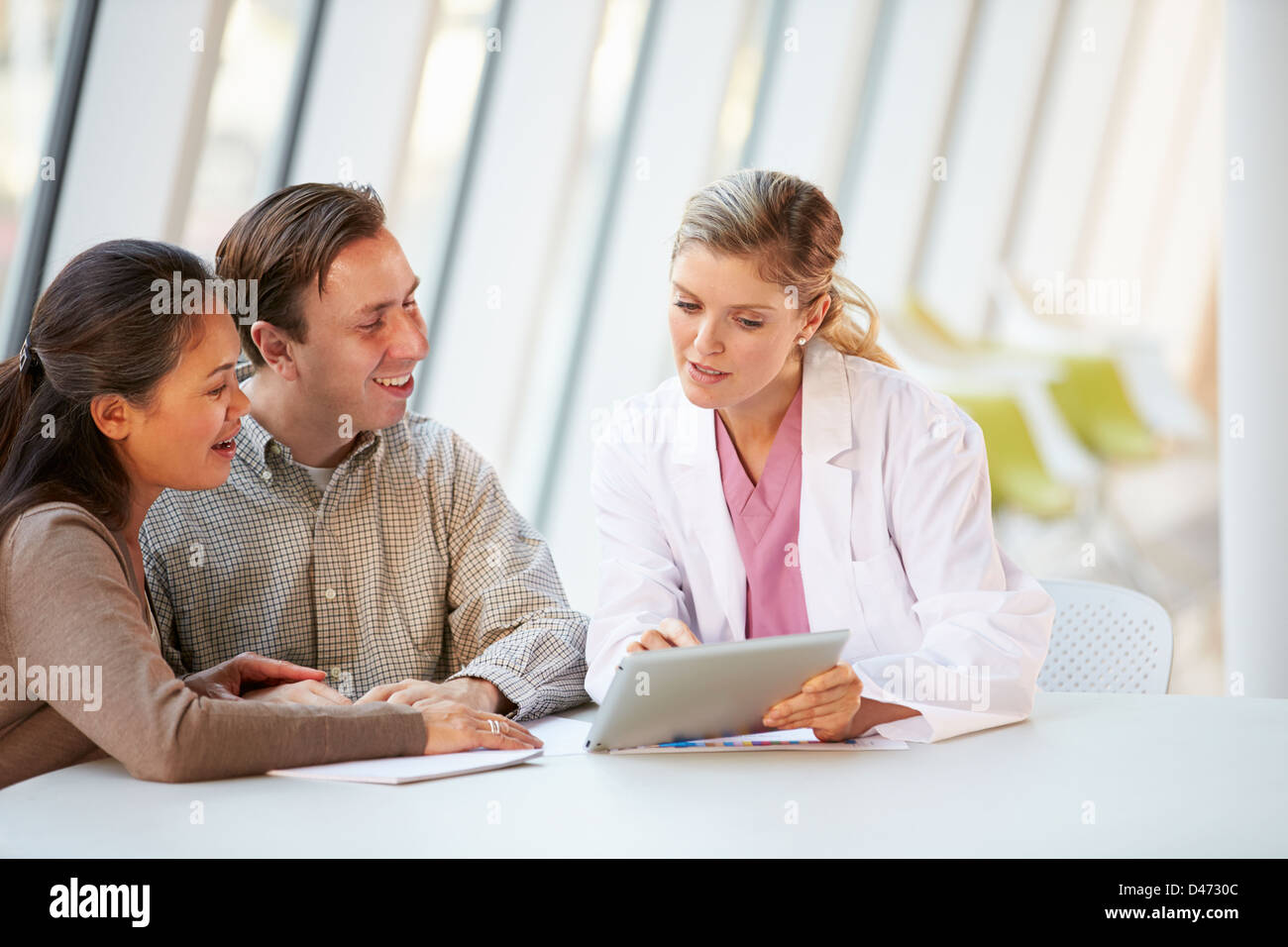 Female Doctor Using Digital Tablet Talking With Patients Stock Photo ...