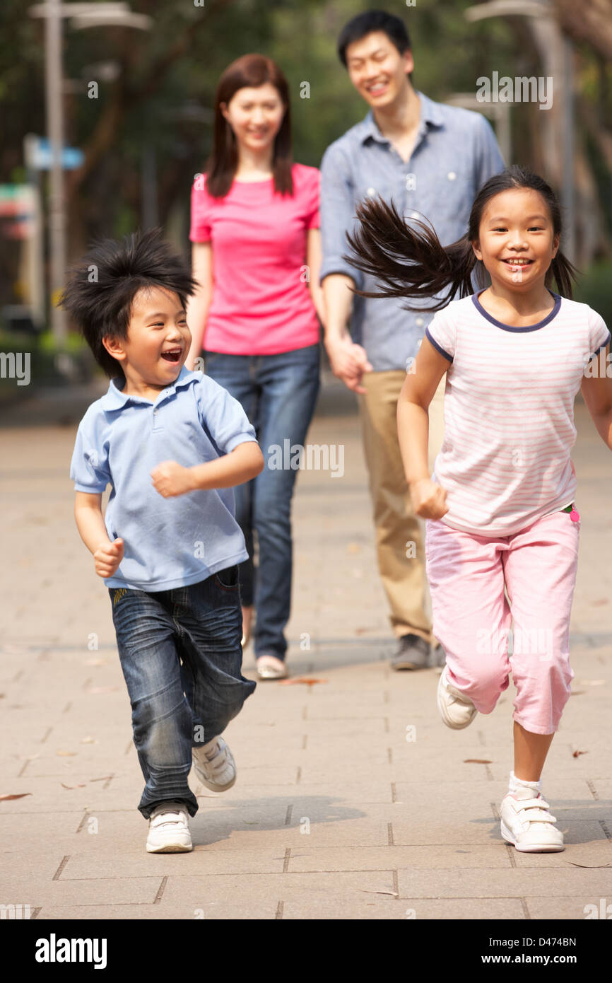 Chinese Family Walking Through Park With Running Children Stock Photo ...