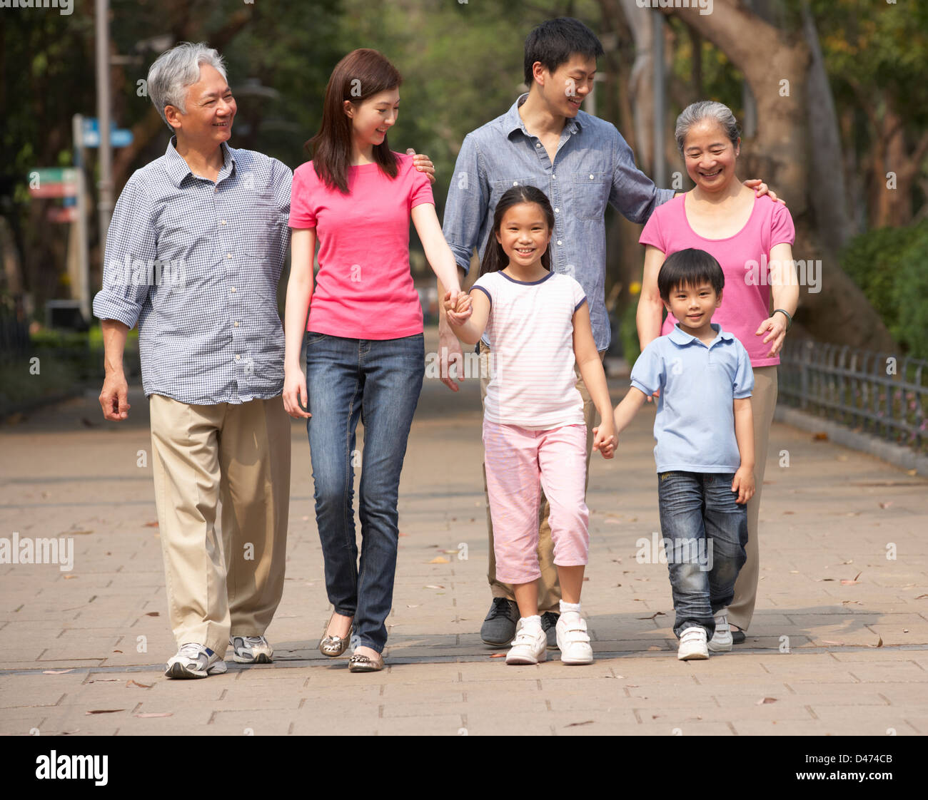 Portrait Of Multi-Generation Chinese Family Walking In Park Together ...