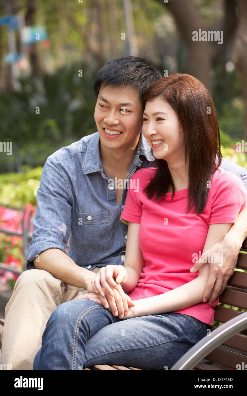 Young Chinese Couple Relaxing On Park Bench Together Stock Photo - Alamy