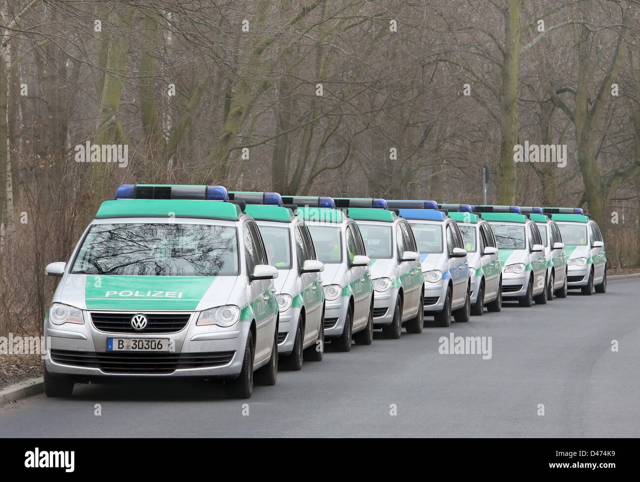 A row of marked police cars stand on a street in the Tiergarten area in ...