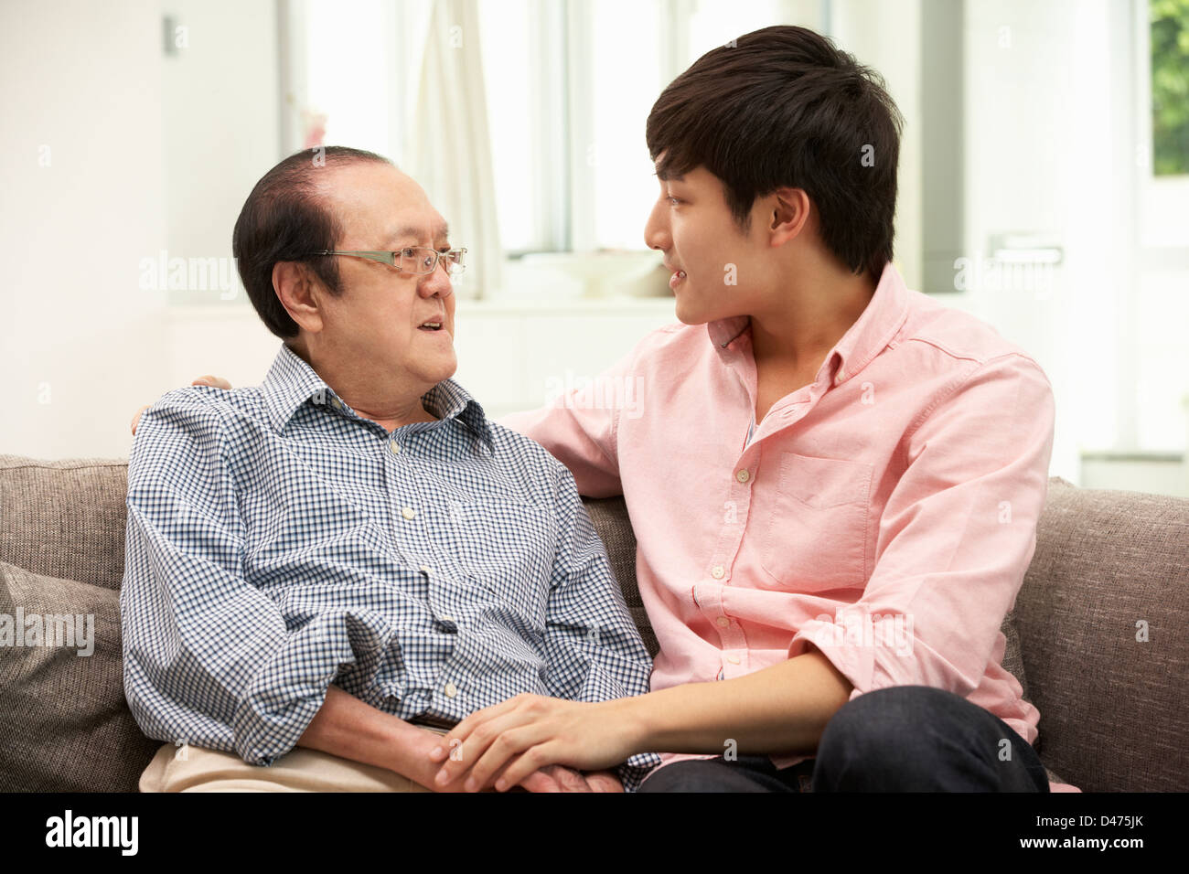 Portrait Of Chinese Father With Adult Son Relaxing At Home Stock Photo ...