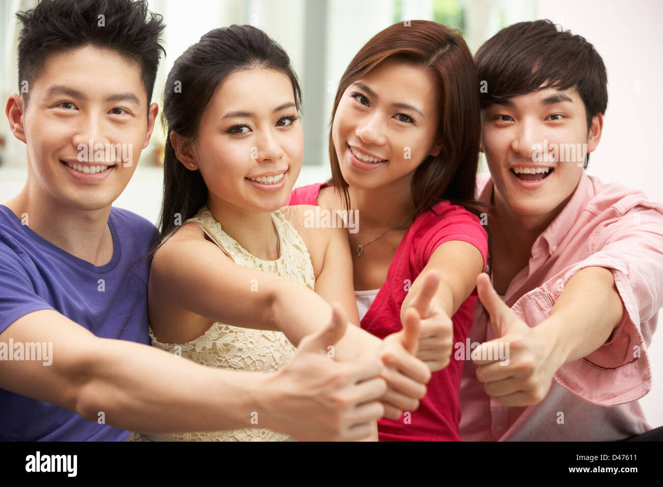Group Of Young Chinese Friends Relaxing On Sofa At Home Stock Photo - Alamy