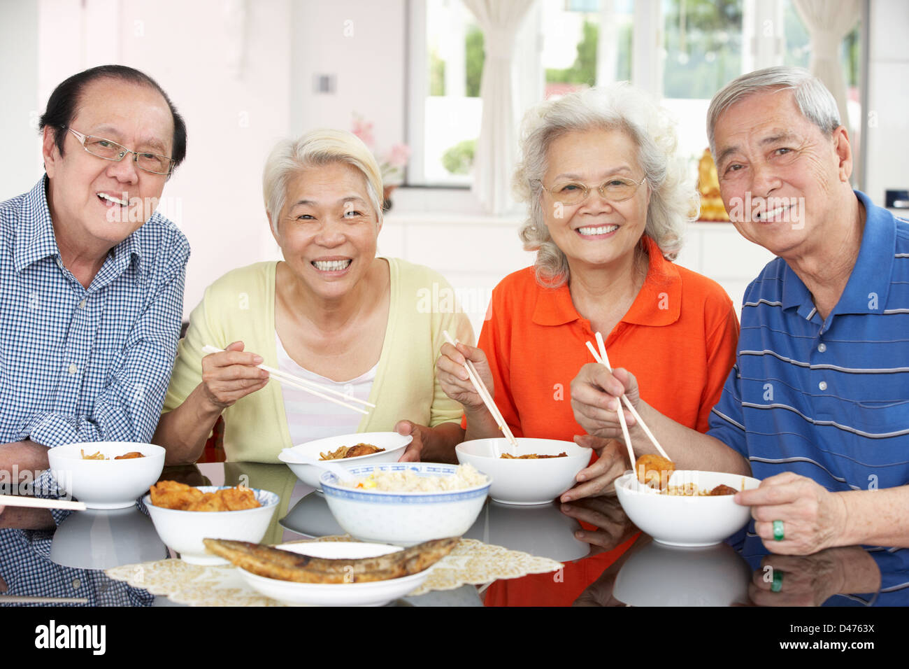Group Of Senior Chinese Friends Eating Meal At Home Stock Photo - Alamy