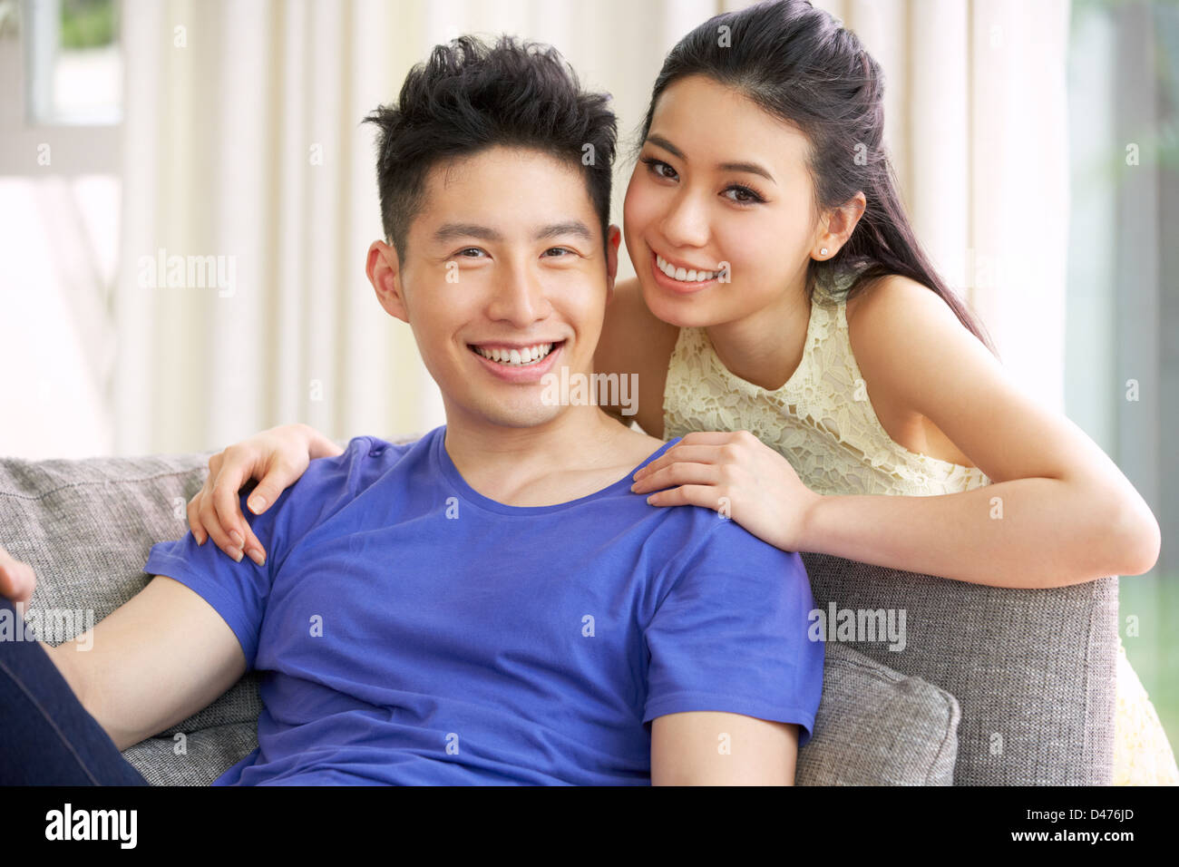 Young Chinese Couple Relaxing On Sofa At Home Stock Photo - Alamy