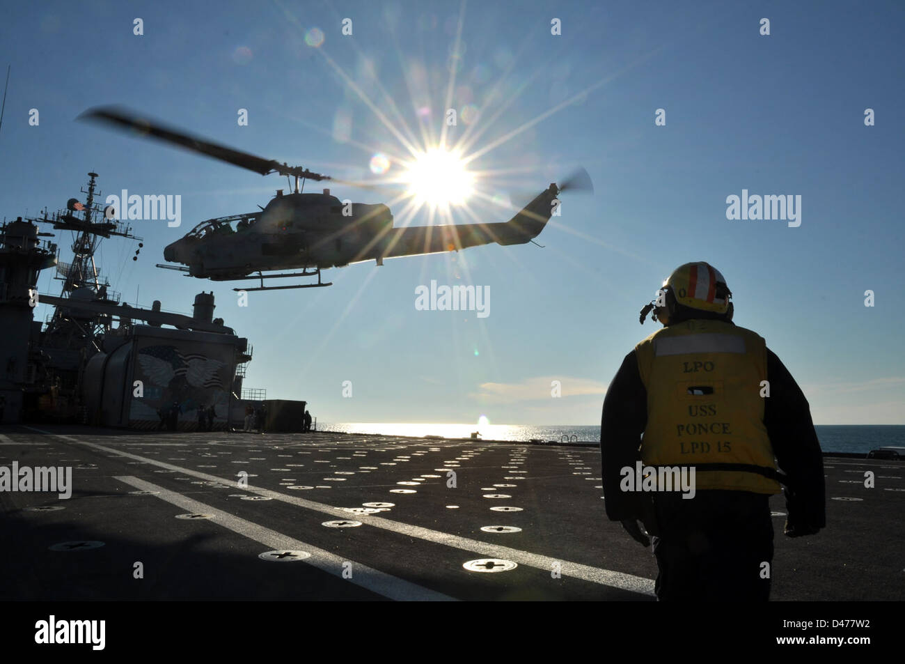 A Sailor observes flight operations and prepares for the next phase of ...