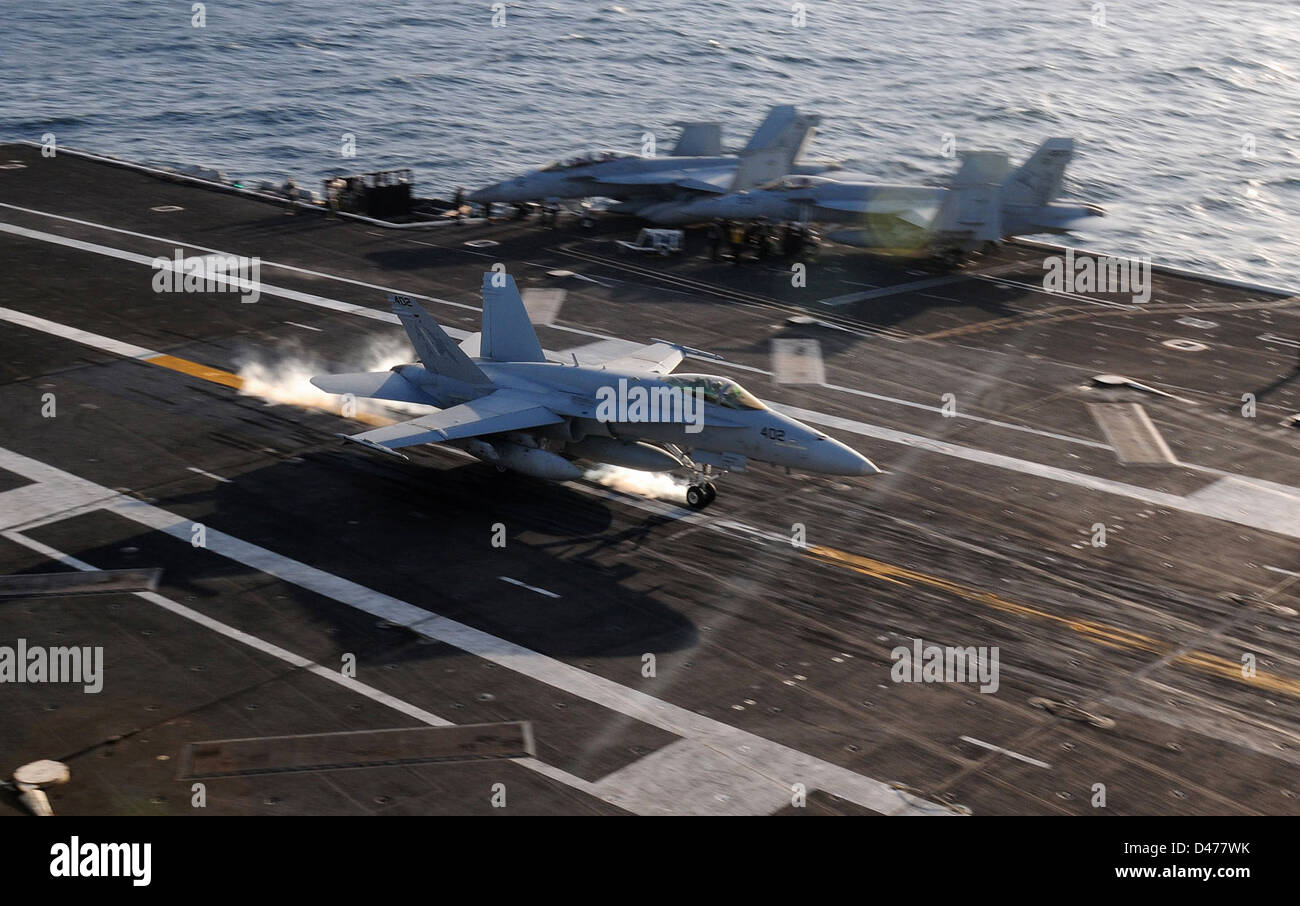 A jet lands on the flight deck of a U.S. Navy aircraft carrier during ...