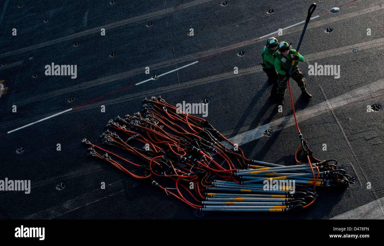 Sailors aboard a U.S. Navy vessel in the Arabian Sea hook cargo nets to ...