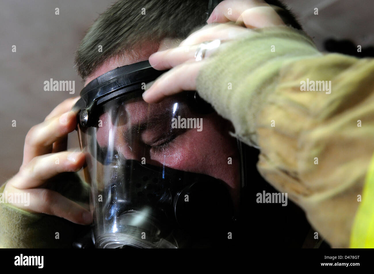 A U.S. Navy Sailor dons firefighting gear during a drill in the Indian ...
