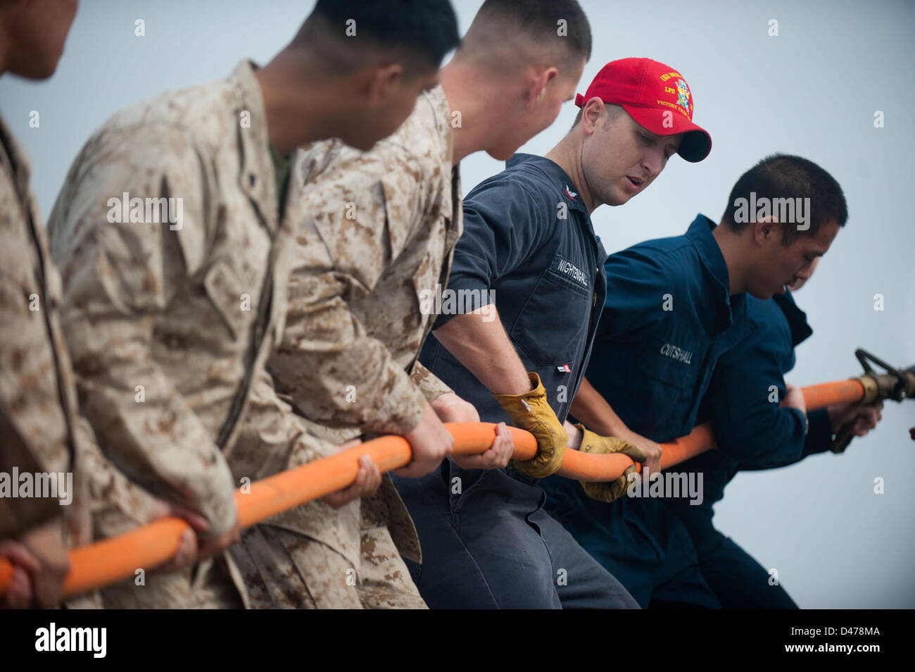 A Sailor demonstrates proper hose handling techniques during a damage ...