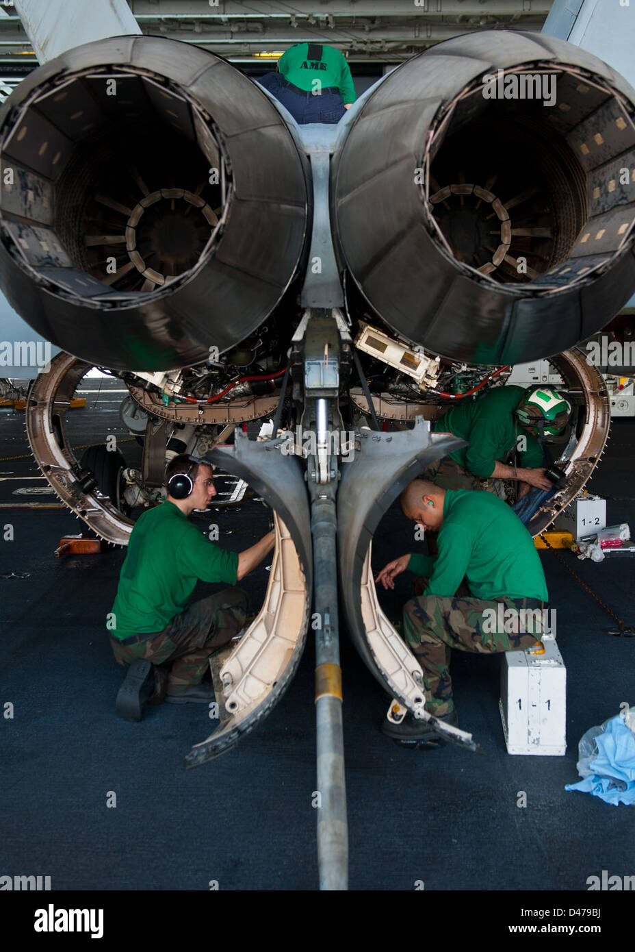U.S. Navy Sailors conduct maintenance on a jet in the Arabian Sea ...