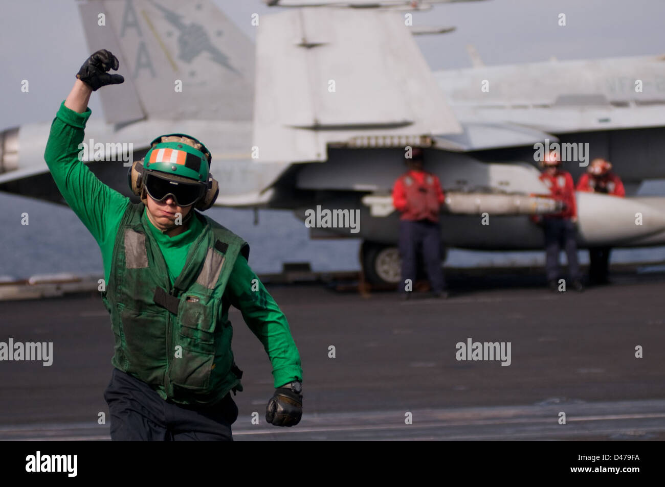 A Navy service member signals a thumbs up before the launch of an ...