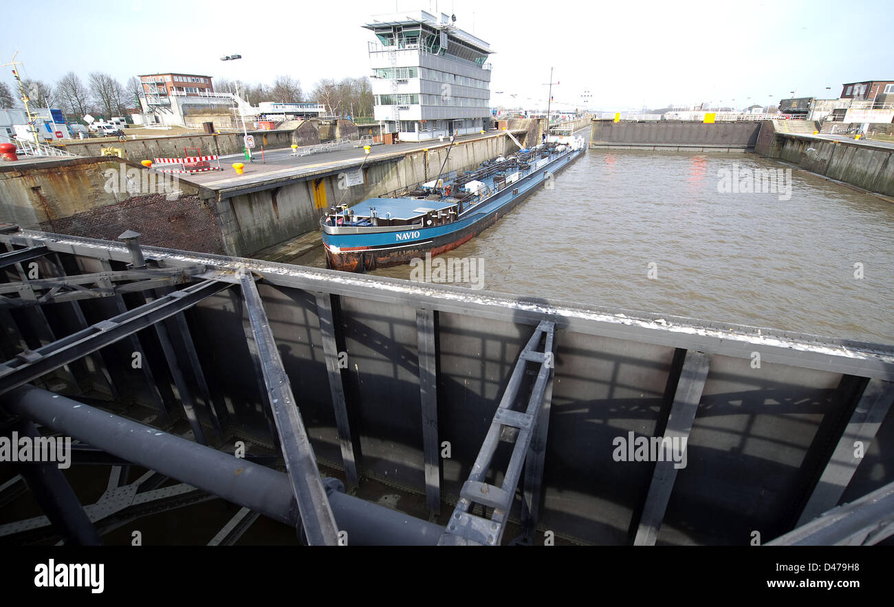 A freighter ship is docked in front of the lock gates at the Kiel Canal ...