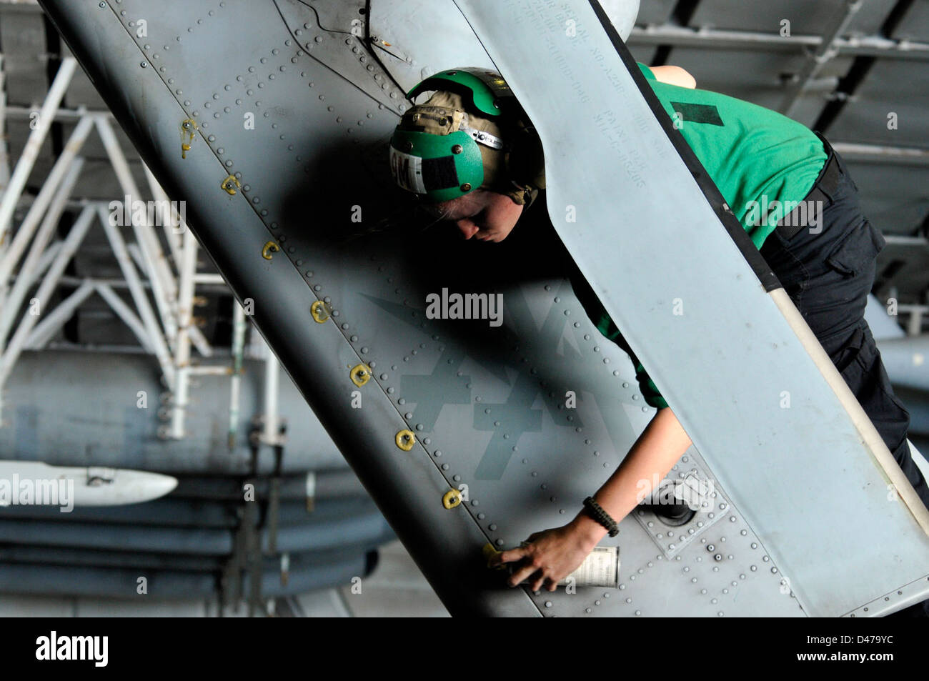 A Sailor conducts corrosion control maintenance on naval equipment ...